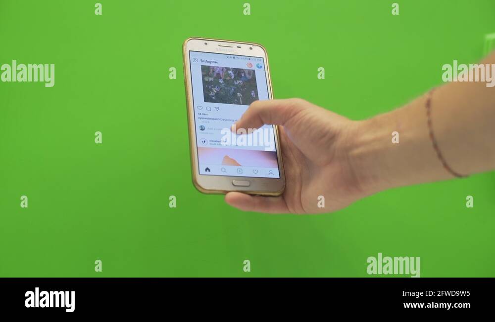 A caucasian hand scrolling through the instagram social media platform ...