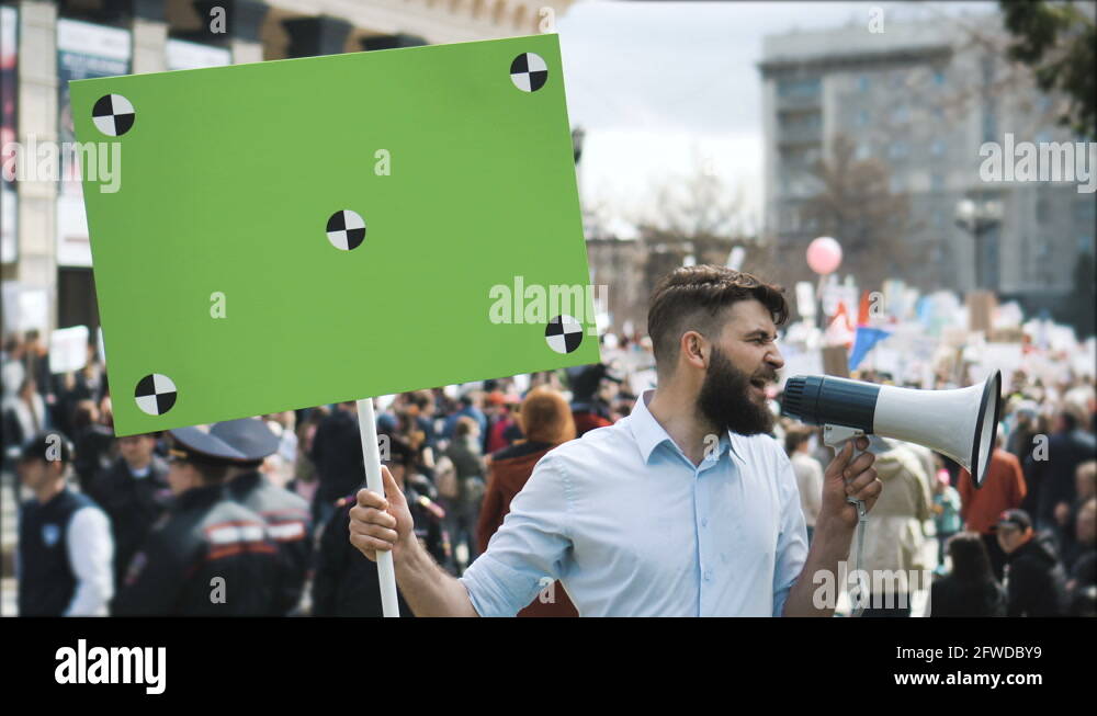 European people at demonstration. Man with a banner screaming into a ...
