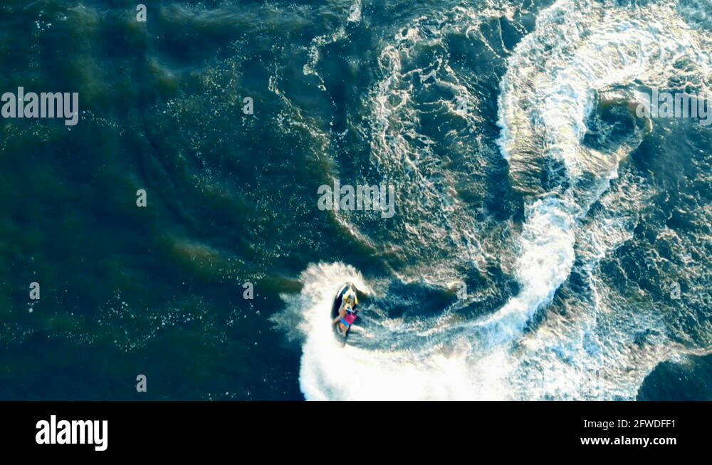 Jetskier is turning on his waterbike, waverunner across the water in a ...