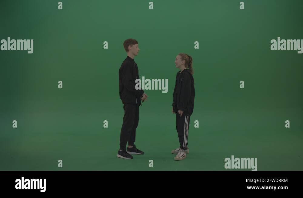Two kids in black wear stare at each other over chromakey background ...