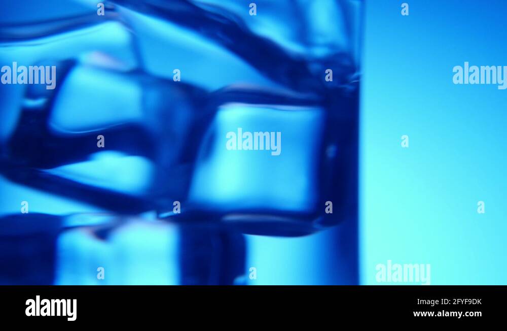 Five ice cubes are shaken in a clear glass in the blue background Stock ...