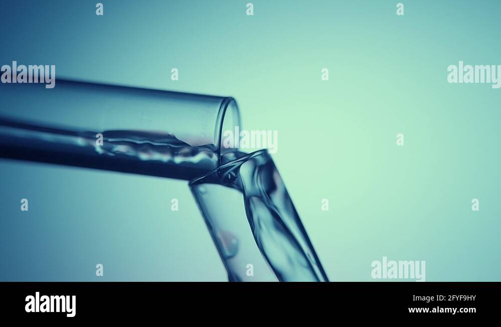 Transparent fluid flows from one test tube into another in a ...