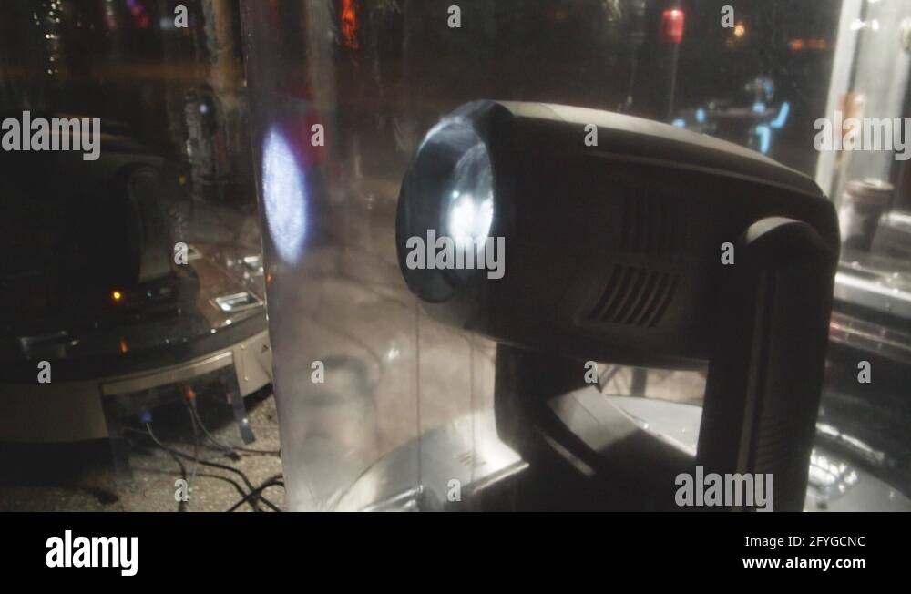 Camera tracks and pans around a projection light and into the beam of ...