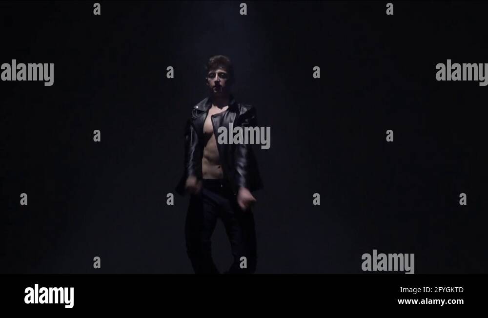 A ballet dancer in a leather jacket shows the movements of a ballet ...