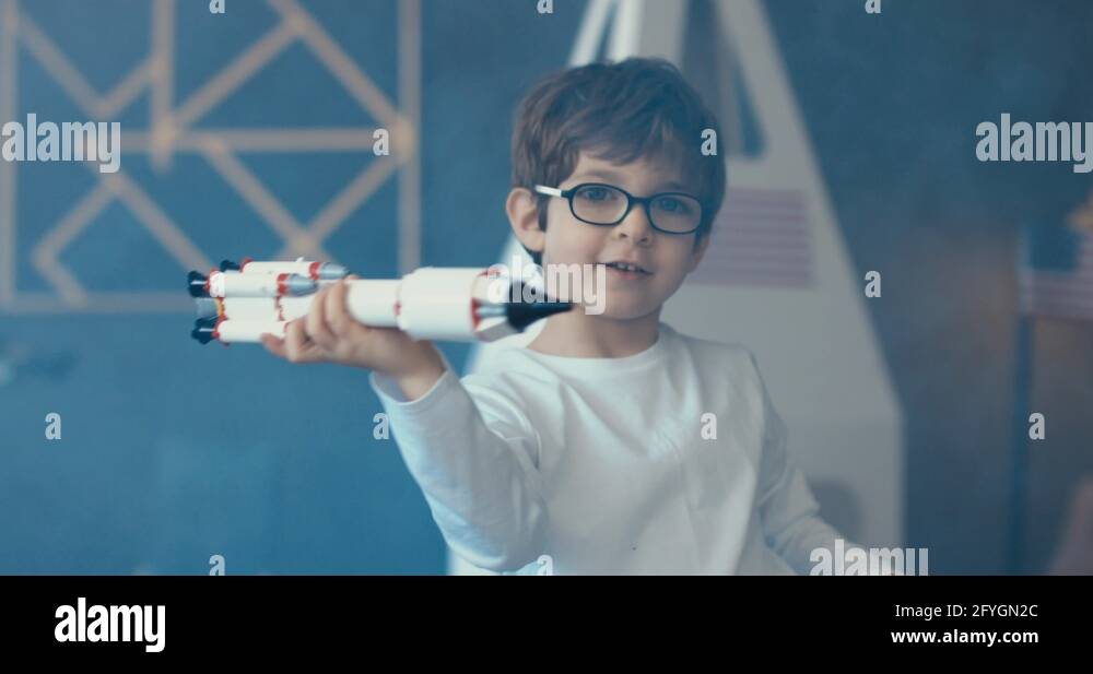 Little boy playing, launching toy rocket through planets, exploring ...