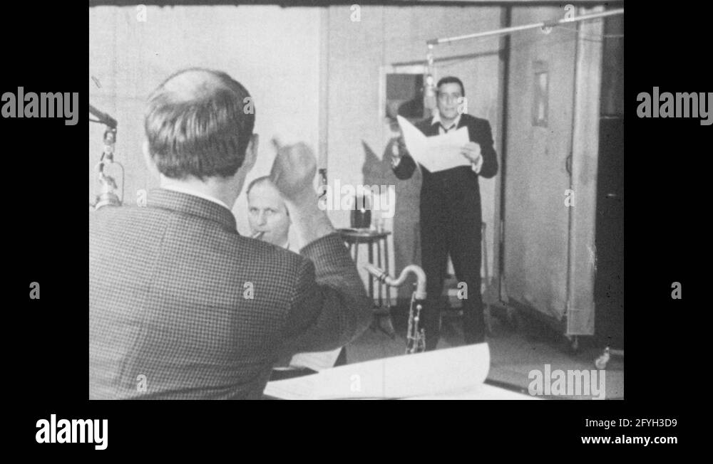 1960s: Conductor points to singer. Tony Bennett sings into microphone ...