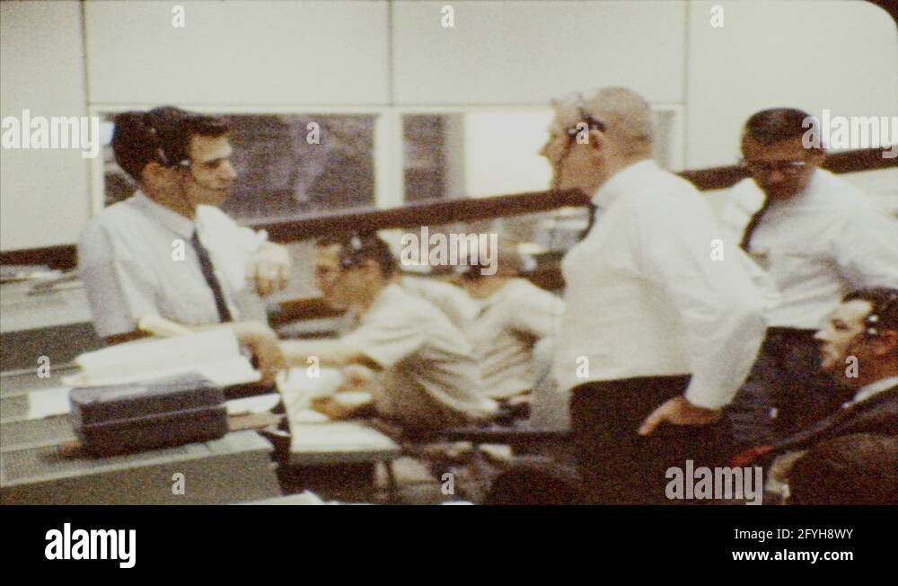 1960s: Men talking. Men talk over control panel. Men talking over ...