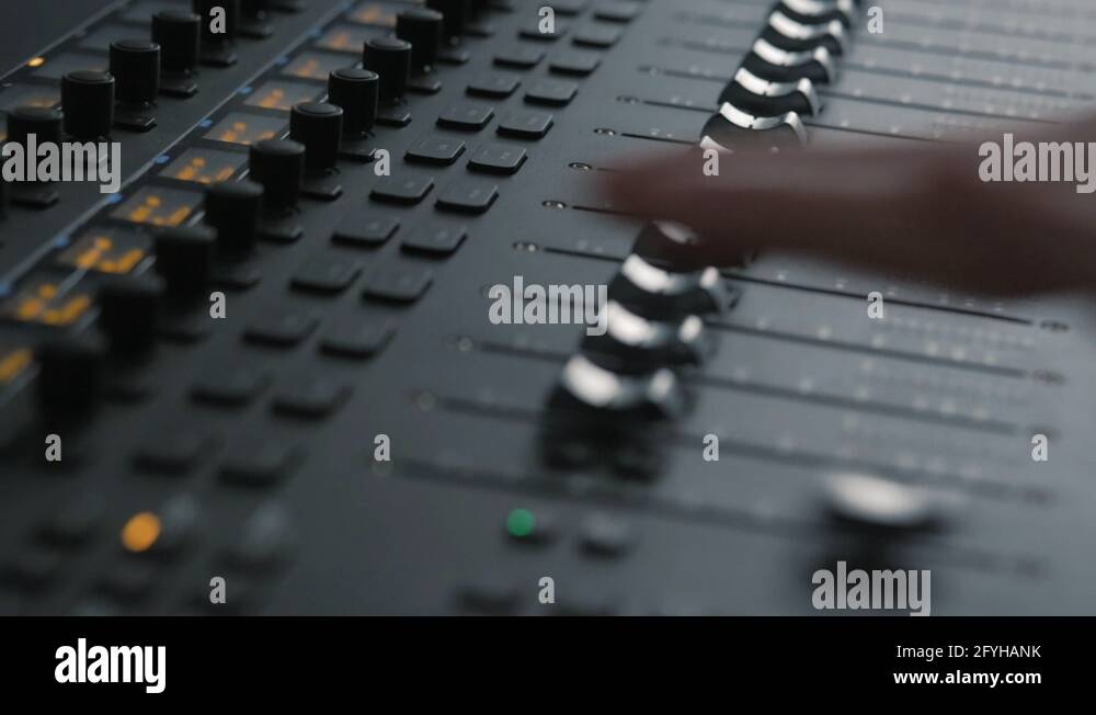Hand moving the knobs on audio workstation mixer console for sound ...