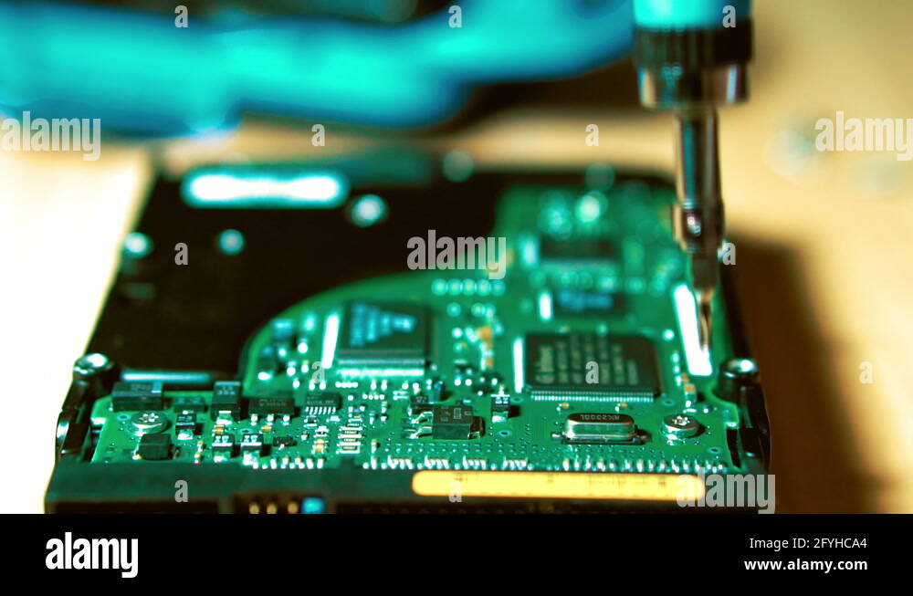 Dismantling the hard drive using hand tools. Screwdriver with ...