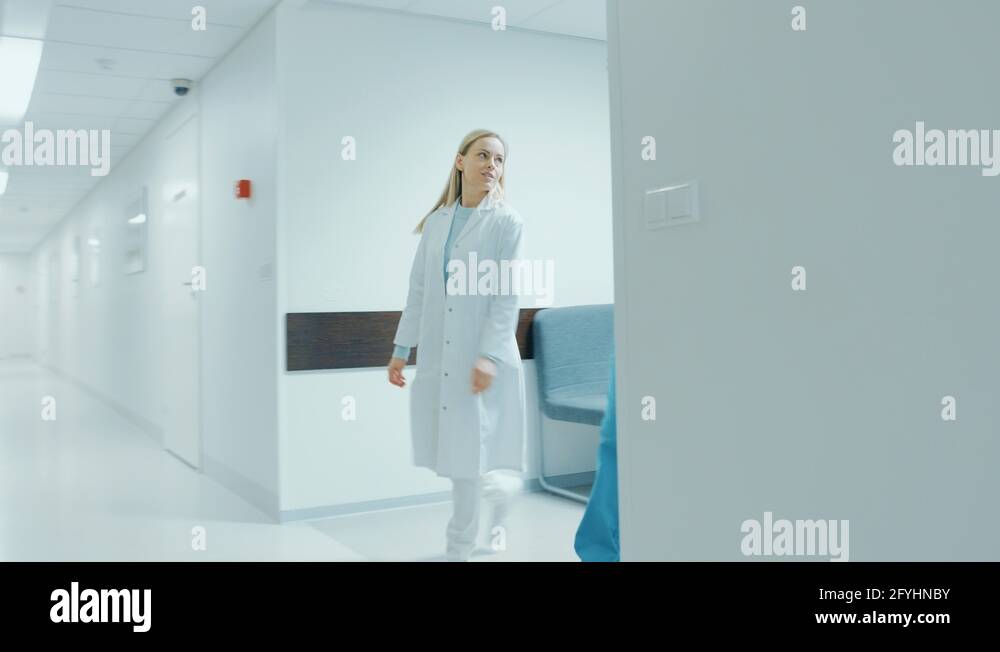 Surgeon and Female Doctor Walk Through Hospital Hallway in a Hurry ...