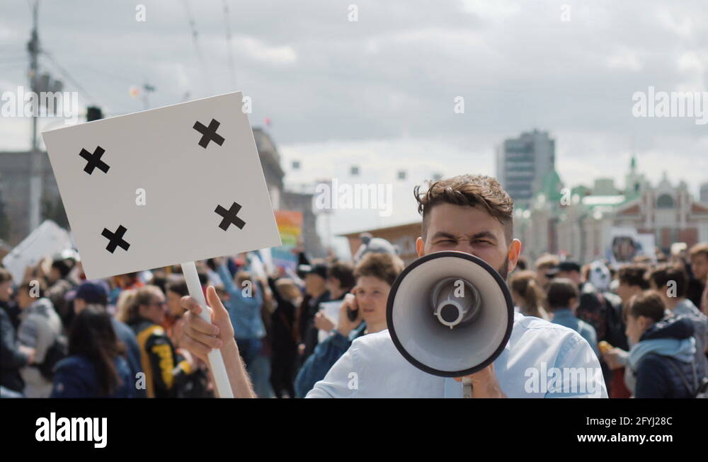 European people at demonstration. Man with a banner screaming into a ...