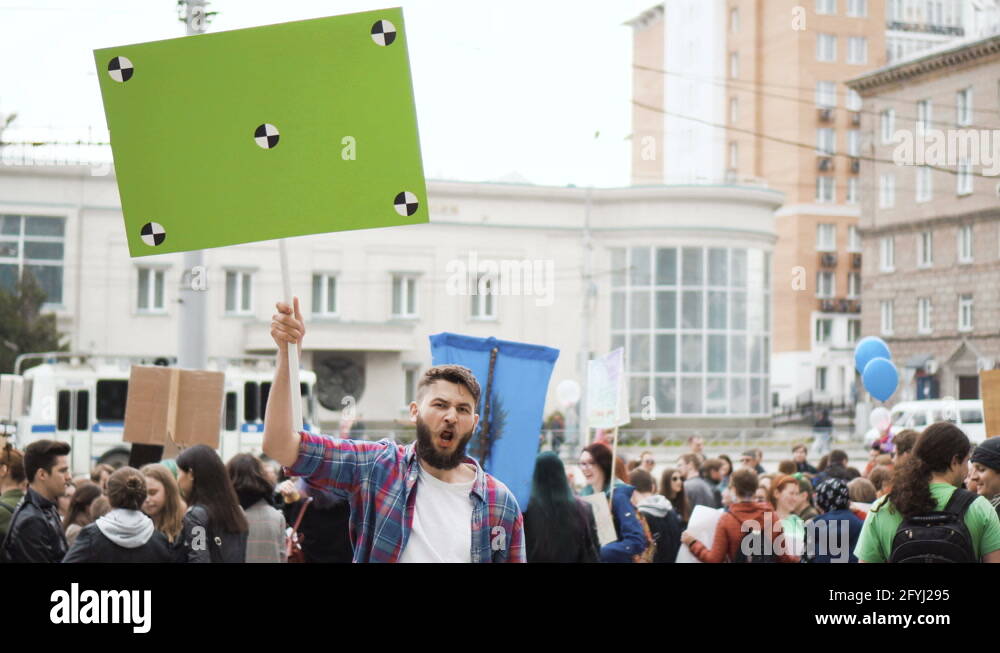 European people at demonstration. Man with a banner screaming into a ...