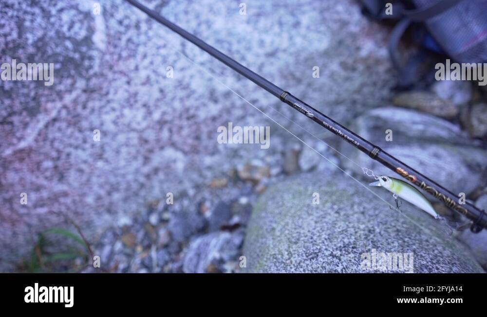 Fishing rod leaning against a stone / rock (slow motion pan shot Stock ...