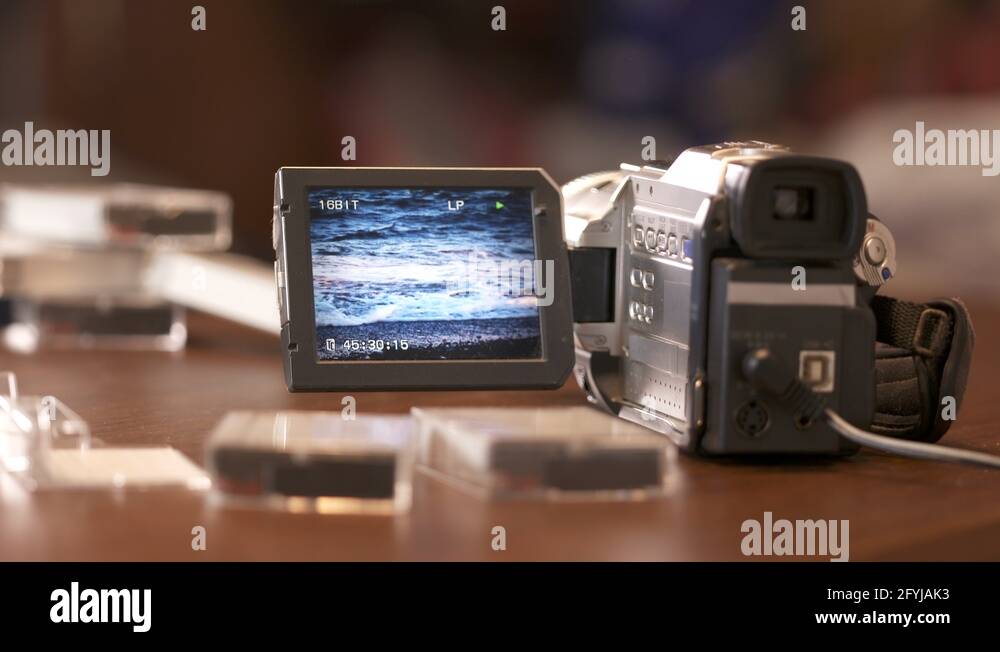 Man watching family home video on LCD screen of digital Mini DV ...