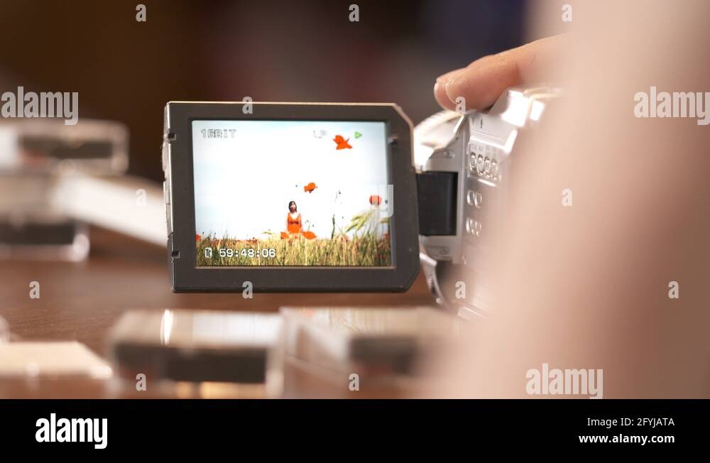 Man watching family home video on LCD screen of digital Mini DV ...