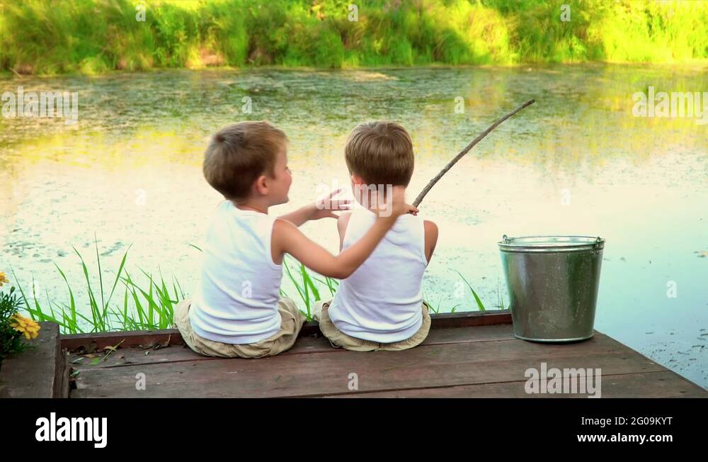 Two brothers fishing in the open air. Beautiful children have a good ...