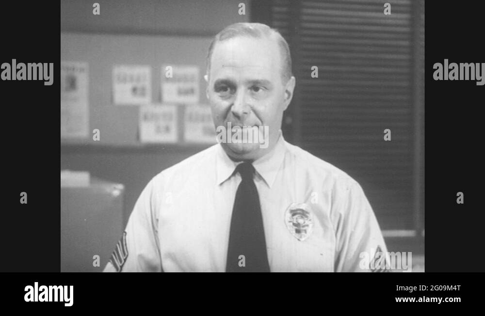 1950s: Police officer and Sergeant talk. Sergeant holds black pin ...