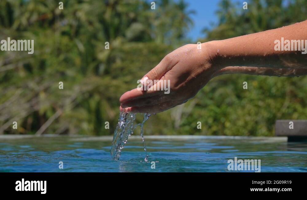 CLOSE UP: Human hand scooping and pouring water making ripples in ...