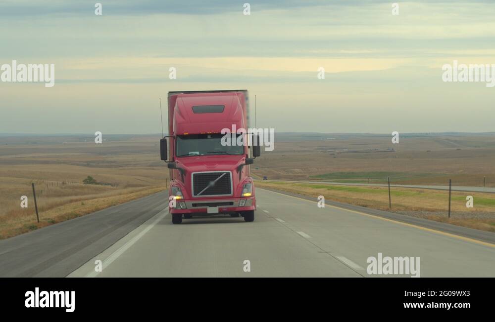 CLOSE UP Driver maneuvering big freight container semi truck driving on ...