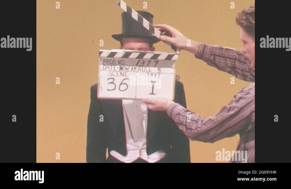 1970s: UNITED STATES: clapper loader stands with clapper board ...