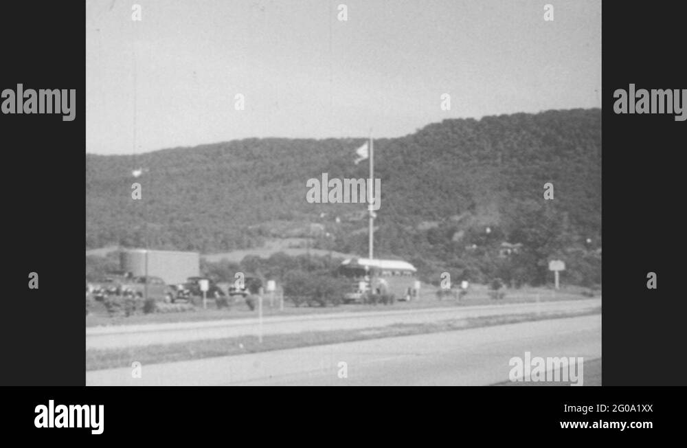 1940s: Bus pulls into rest stop. Bus door opens, driver steps out ...