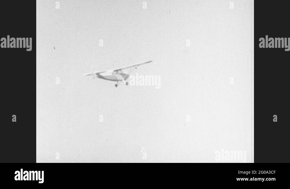 1950s: small private Piper Cub airplane flies in the sky. boy in ...