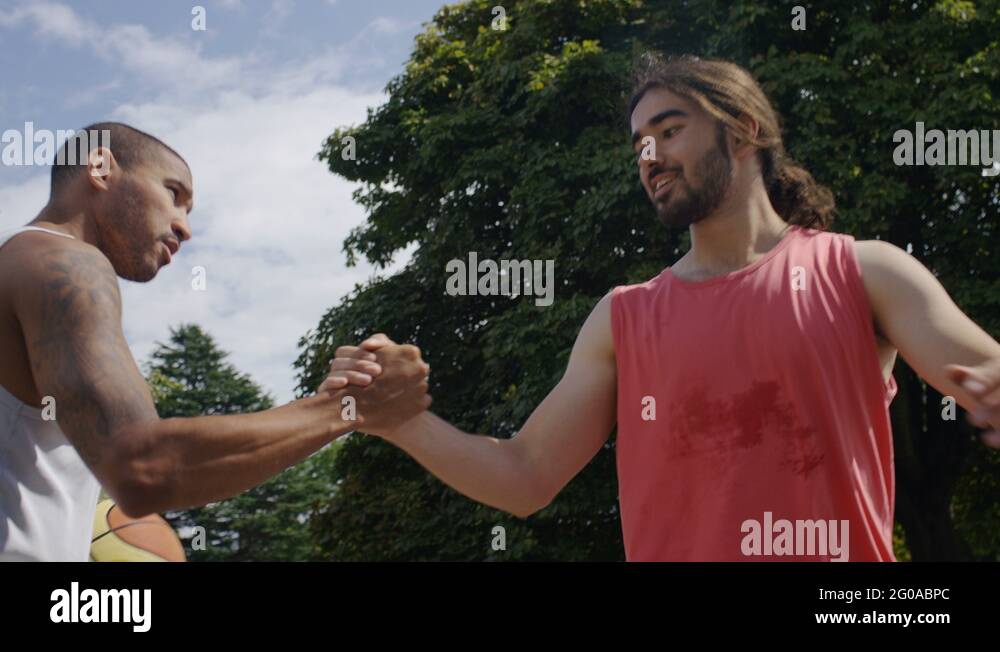 Two players in a one on one basketball game give each other a high five ...