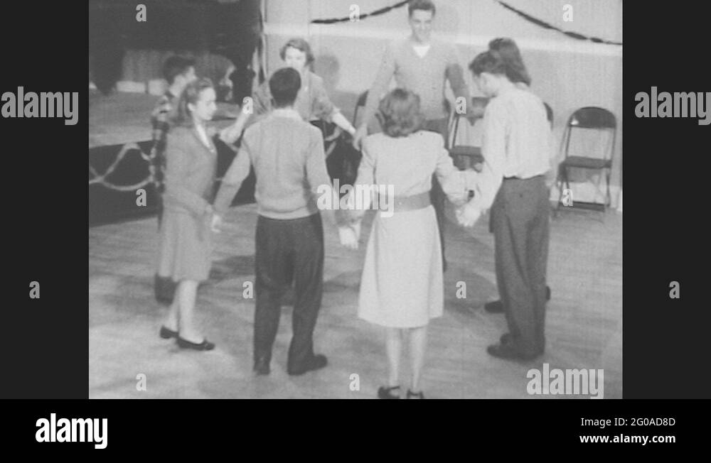 1950s: Group of dancers form couples. Men and women dance. Man sings ...