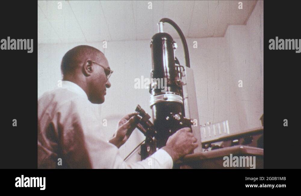 1970s: Man uses large microscope. Men use microscope. Suited men flip ...