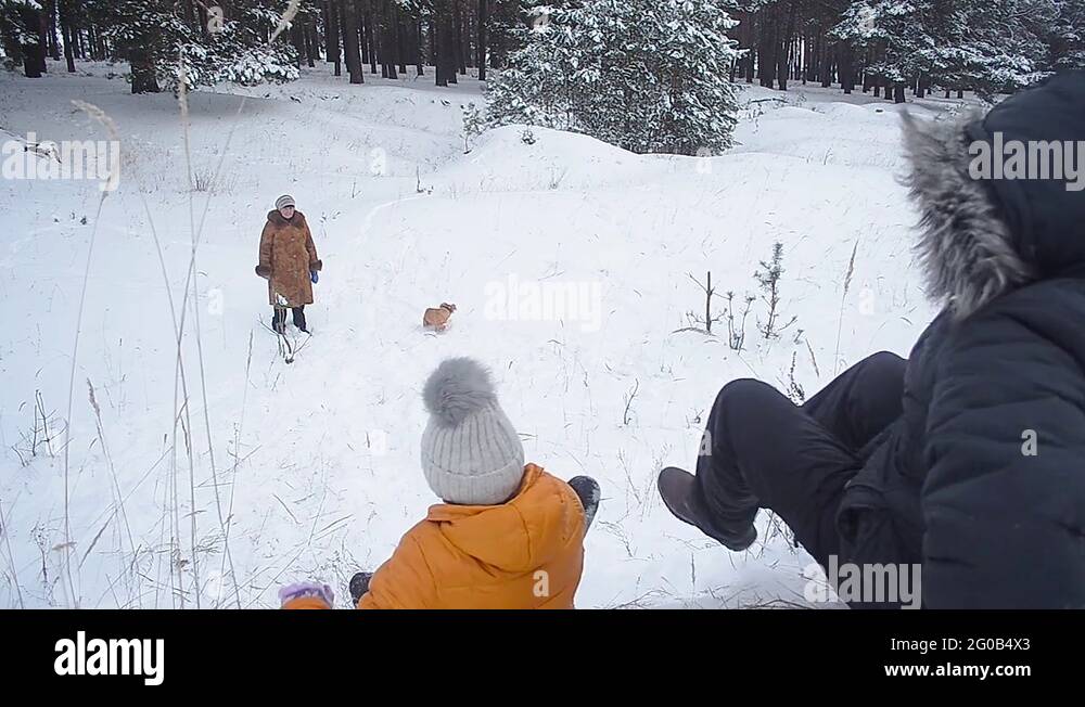 Dad and daughter ride on a sled in winter with snow slides, a family ...