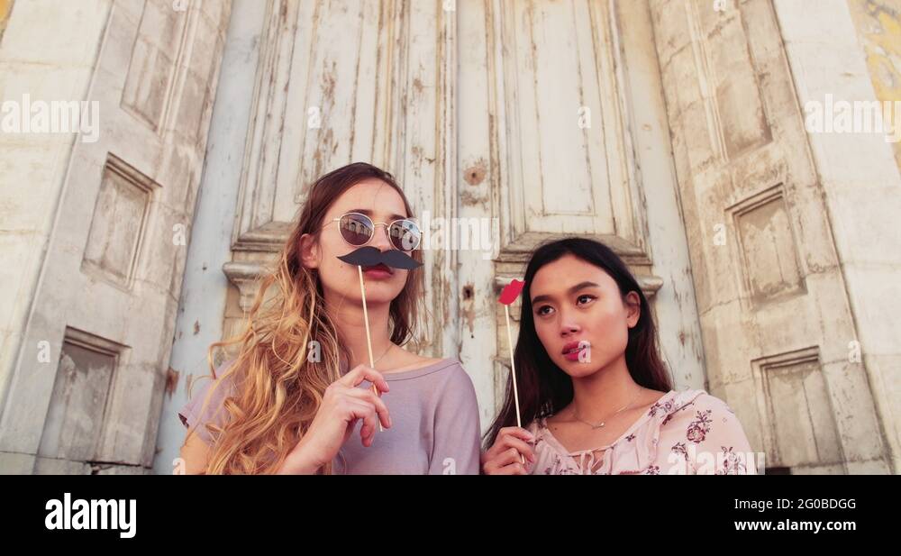 Women playinig with fake mustaches and lips in old street Stock Video Footage - Alamy