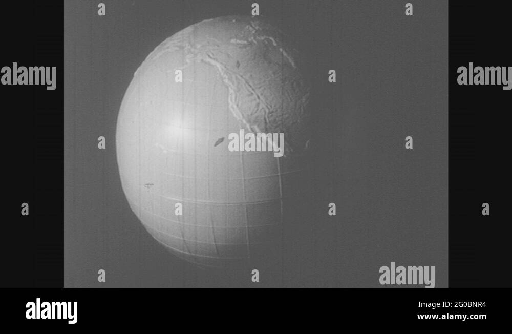 1950s: United States: Rotating Model Of Earth. Map Of World. Men Stand ...
