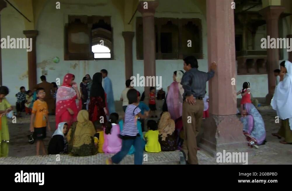 Little Girl Walking Around Near Families And Pillars - Pan - Left To ...