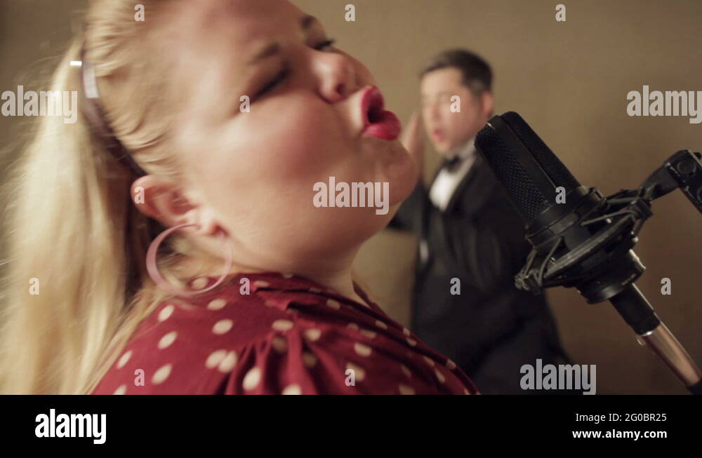 Three musicians and a cheerful fat girl sing and dance in the recording ...