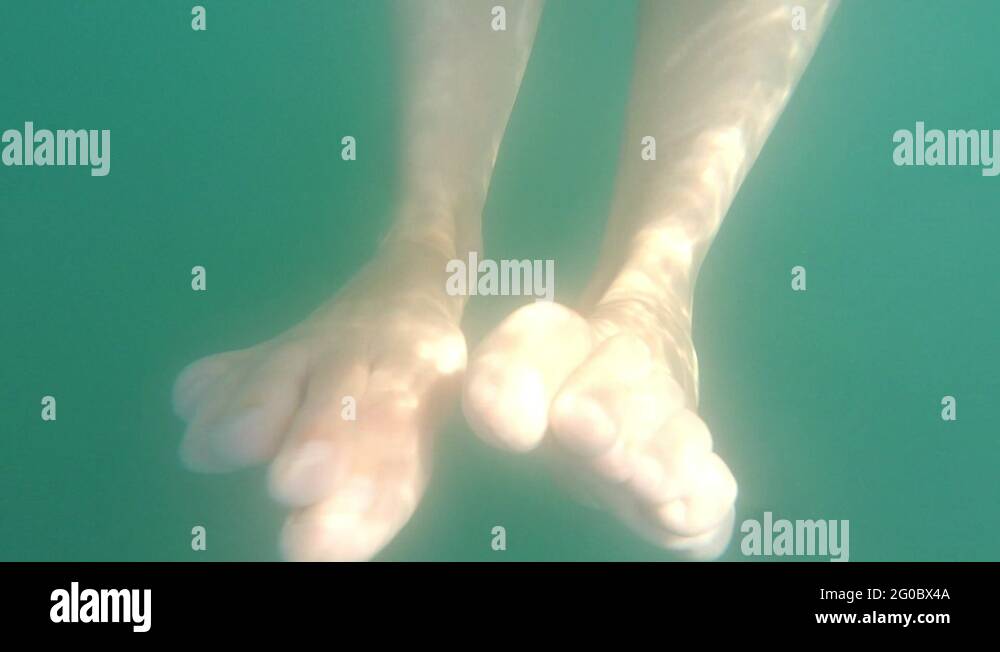 POV Toes of swimmer in sea water Summer Stock Video Footage - Alamy