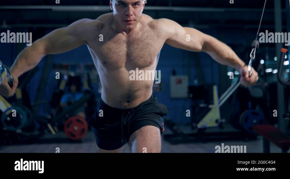 bodybuilder doing exercise on the simulator in the gym. exercises for ...