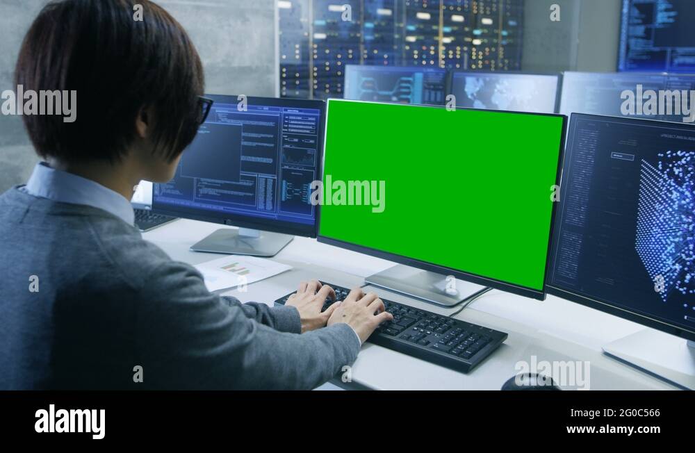 Operator Working at His Workstation with Green Screen Mockup Display ...