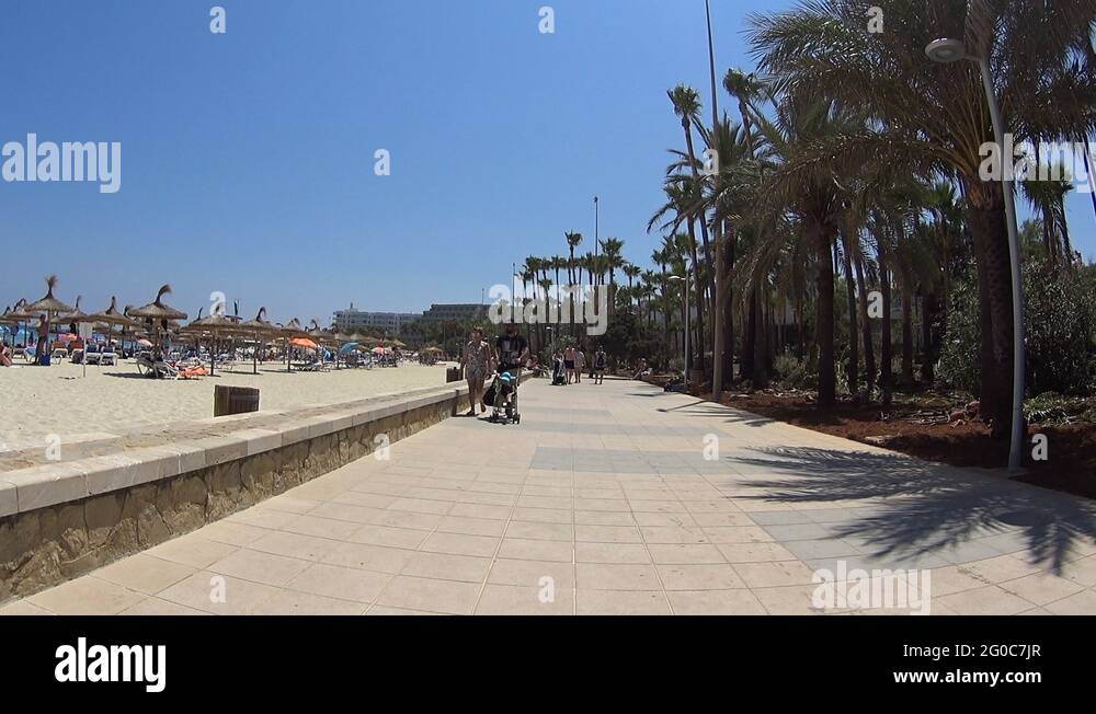 Sa Coma Mallorca Spain: Tourists walking and cycling on the beach ...