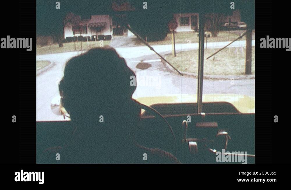 1970s: Bus driver looks both ways, approaches stop sign and stops. Bus ...