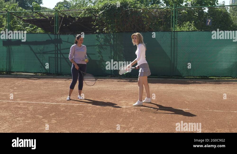 Young woman takes tennis classes and learns how to hold tennis racket ...