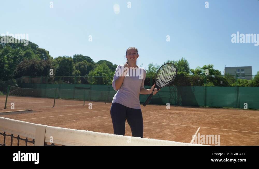 Winner of a tennis game comes to the fillet laughing happy holding her ...
