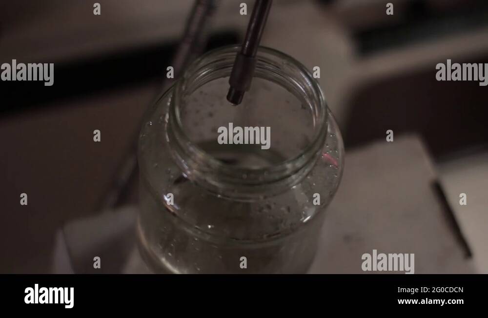 Alcohol distillation equipment, hooch fluid flow into glass jar Stock ...