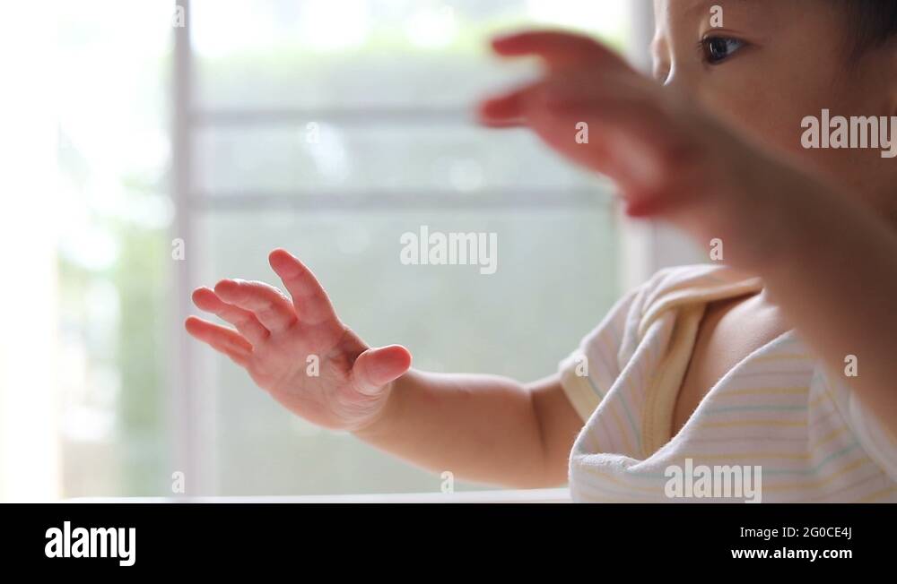 baby boy training eating food with finger pick up snack from hand ...