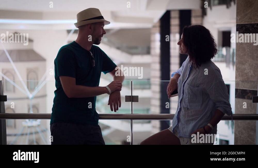 A pretty woman with short and wavy hair talking with a tall man who put ...