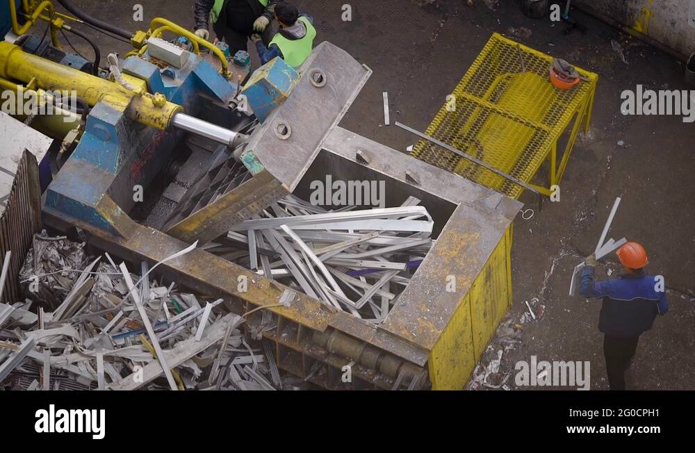 huge hydraulic scrap baling press machine is working, pressed metal ...