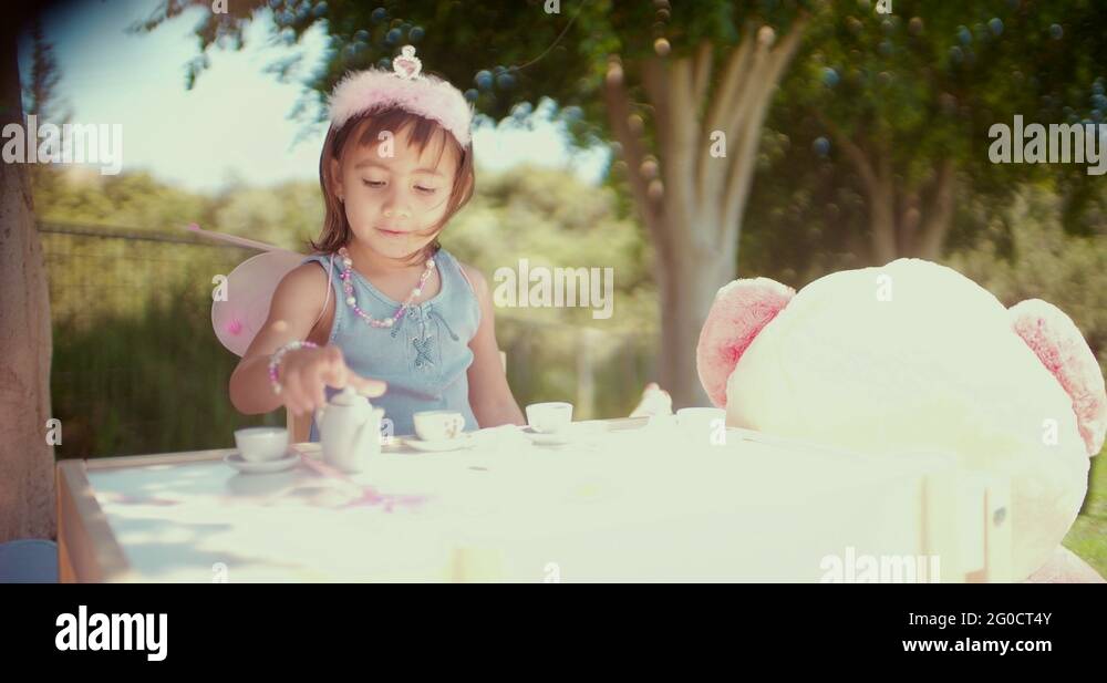 Cute little girl serving tea at pretend garden tea party Stock Video ...