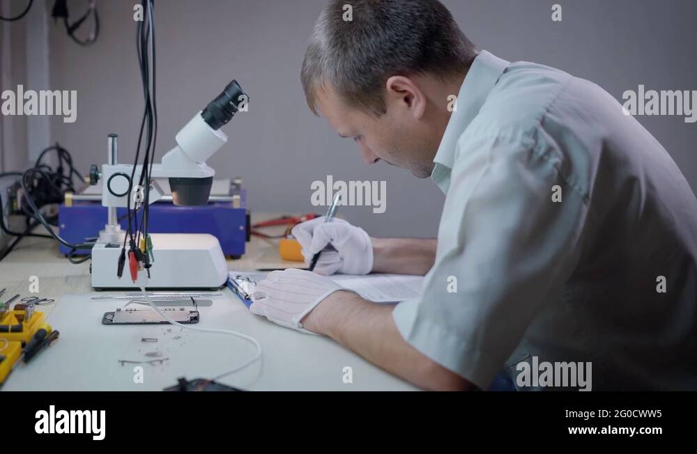 Serious scientist writing report while working in new special ...