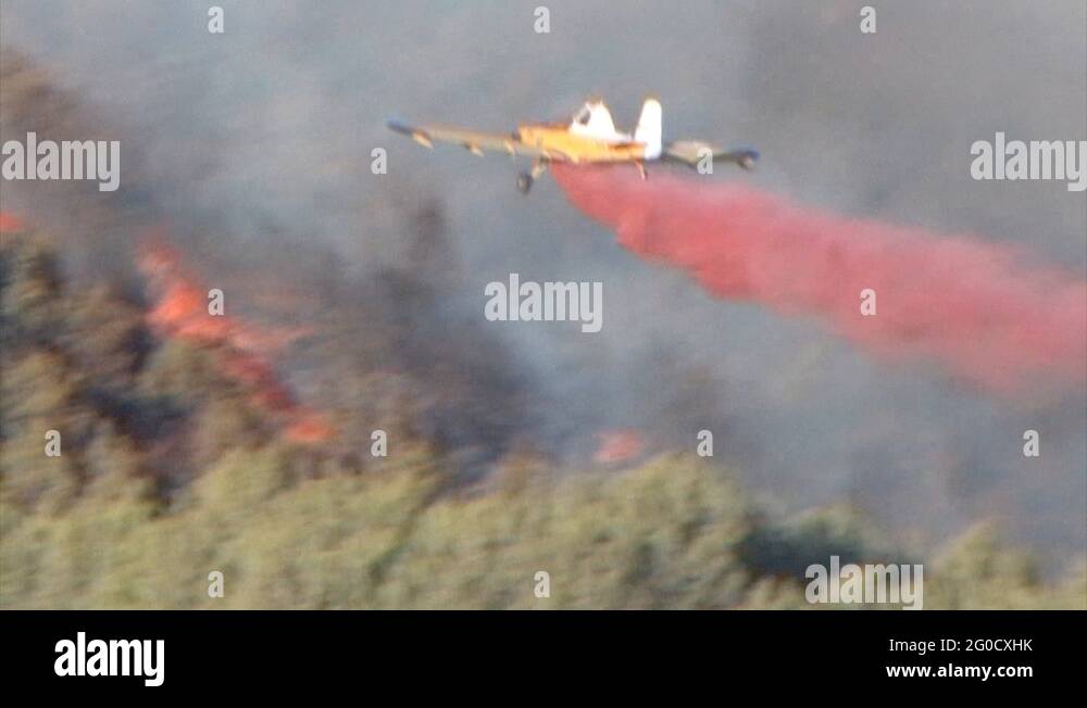 Fire fighting plane fly low and spray fire extinguisher on forest Stock ...