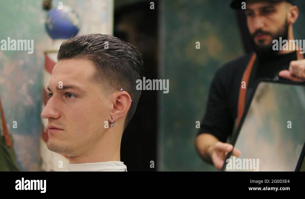 Professional hairdresser shows the back view of the haircut using ...