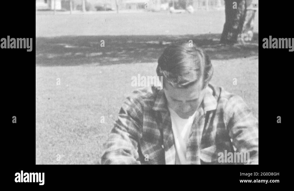 1960s: Young man looking at ground, looks and grimaces/looks ...
